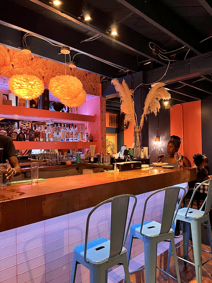 The bar doesn't whisper "good morning"—it announces it with fluffy pendant lights and a coral backdrop that wakes you up before the caffeine does.