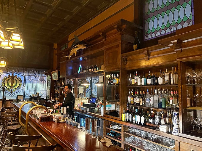 The bar at Bender's isn't just serving drinks – it's preserving history with stained glass, polished wood, and bottles lined up like soldiers ready for duty.