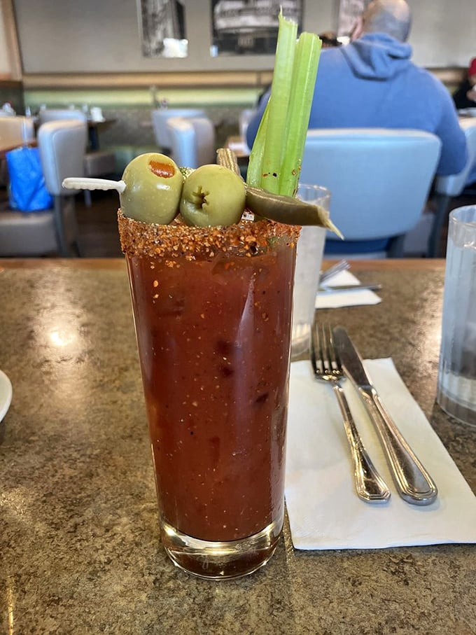 This Bloody Mary isn't playing games—it's a meal in a glass that comes with its own garden of garnishes and enough spice to wake the dead.