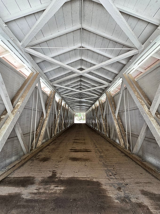 Inside the bridge, a geometric wonderland of white timber framing creates a tunnel-like passage that's equal parts functional engineering and accidental art.