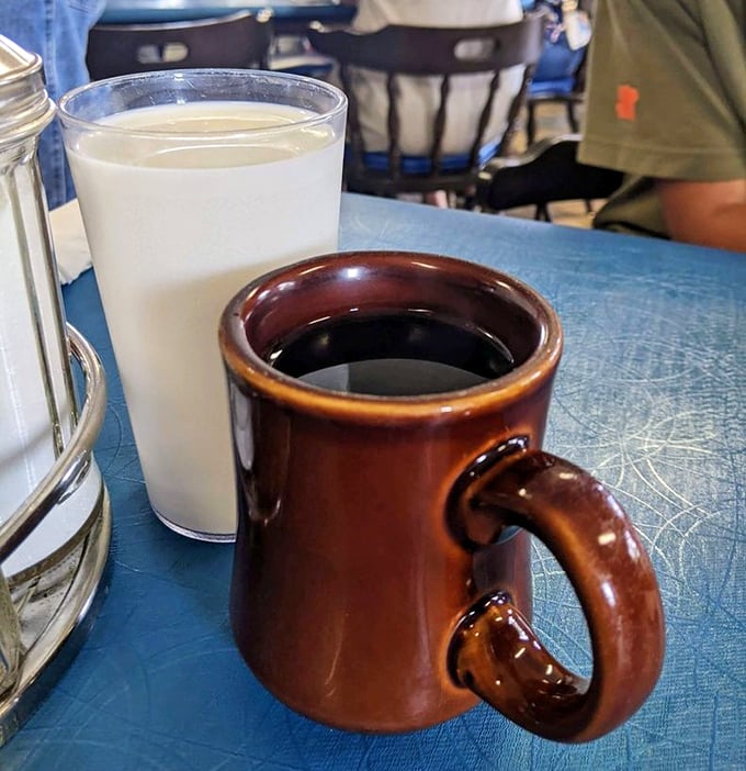 The classic diner duo – coffee in a sturdy brown mug and milk in a tall glass. Simple pleasures that somehow taste better here.