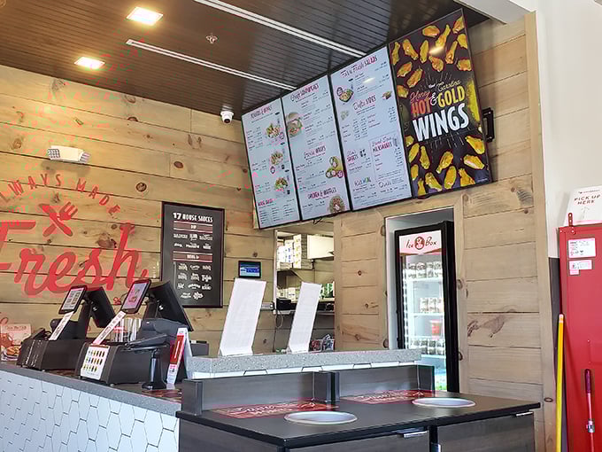 Behind wooden panels and hexagonal tile, culinary magic happens—the ordering counter where chicken dreams begin their journey to reality.