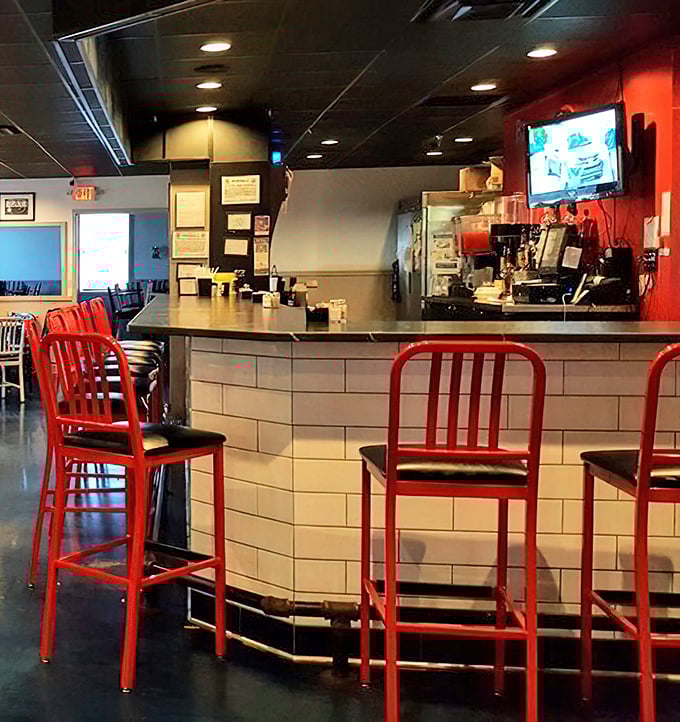 The counter where magic happens – red stools invite you to sit and watch the choreography of a well-run kitchen in action.