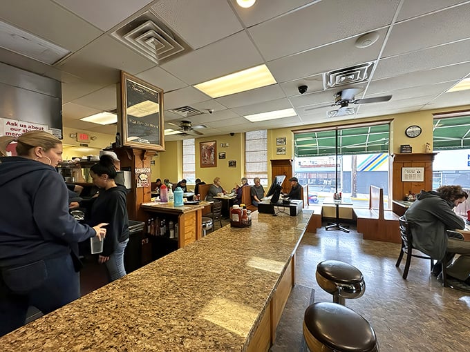 The counter view – where breakfast dreams materialize before your eyes and coffee cups never stay empty for long.