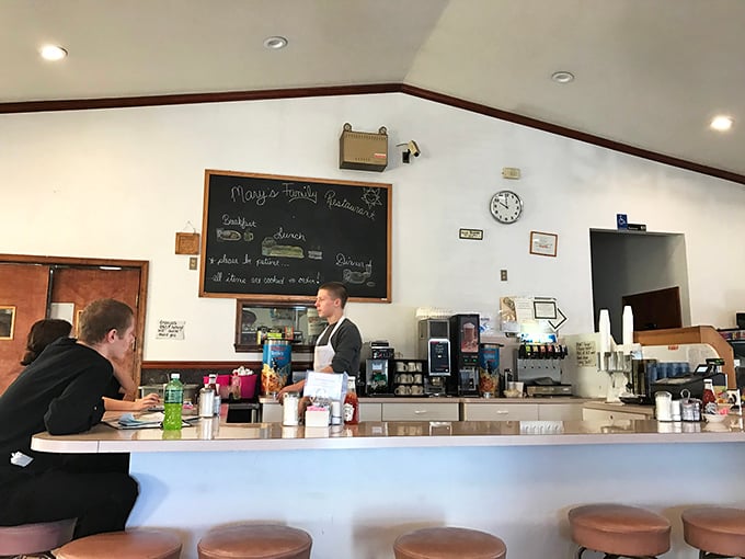 Behind the counter, where the magic happens – a chalkboard menu promising "all items are cooked to order" isn't just words, it's a philosophy.
