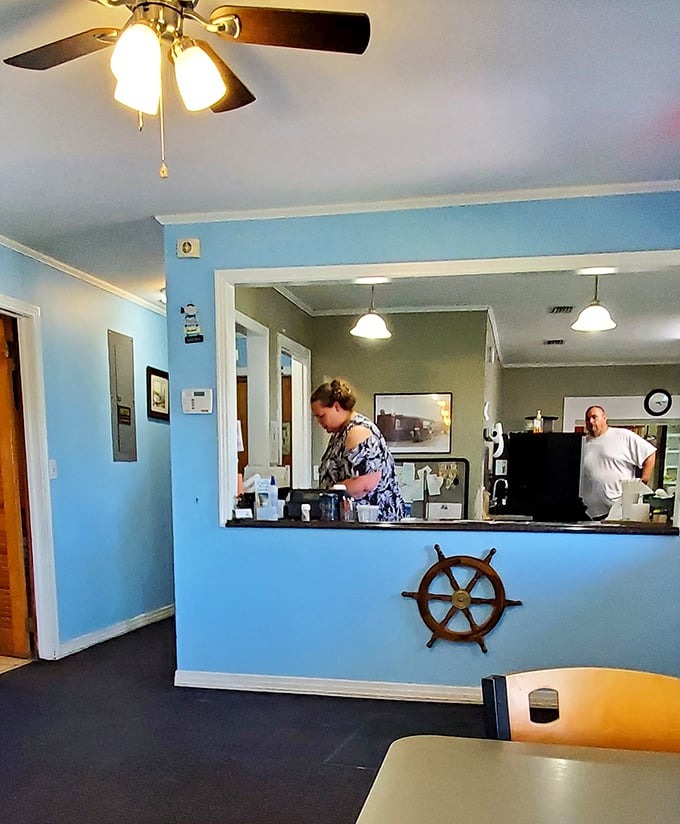The blue reception counter with its ship's wheel isn't trying to be nautical-cute—it's just acknowledging where your dinner came from. Respect the source.