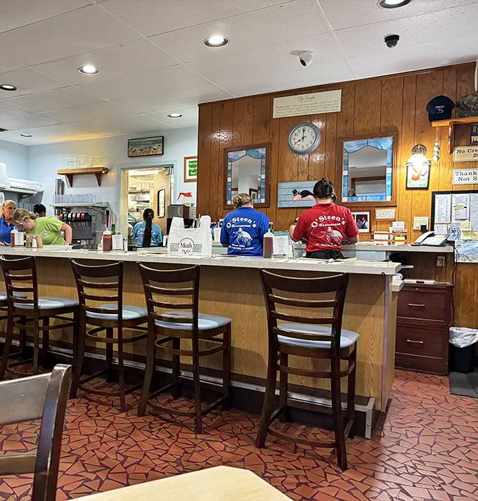 The counter where regulars perch like seabirds, watching the choreographed dance of servers and cooks during the lunch rush.