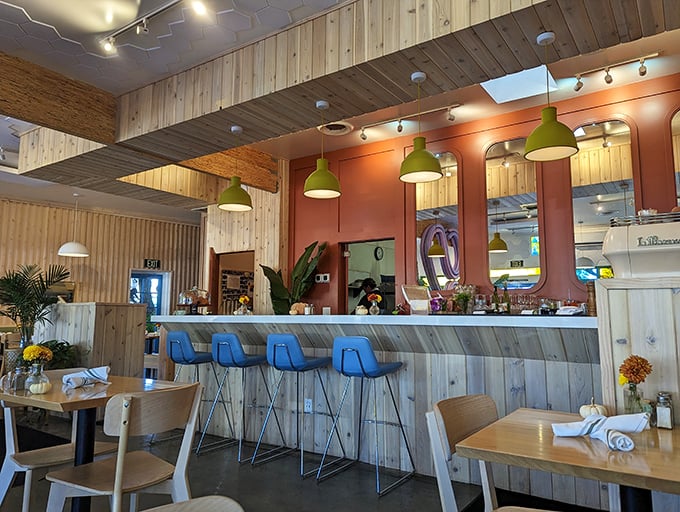 The bar area combines light wood, blue accents, and hanging plants—like someone designed the perfect breakfast spot after a particularly inspiring trip to Bali.