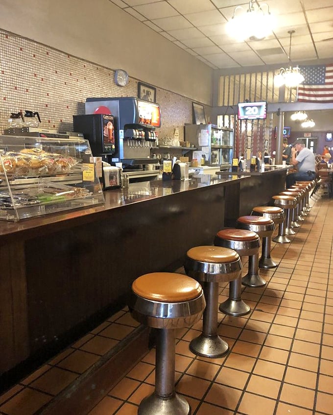 The counter where regulars claim their territory, where coffee refills appear magically, and where the world's problems are solved daily between 6 and 10 AM.