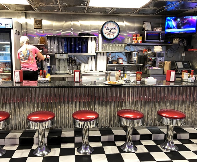 The counter is where the magic happens—classic chrome stools with red vinyl tops invite you to sit and watch short-order wizardry unfold before your eyes.