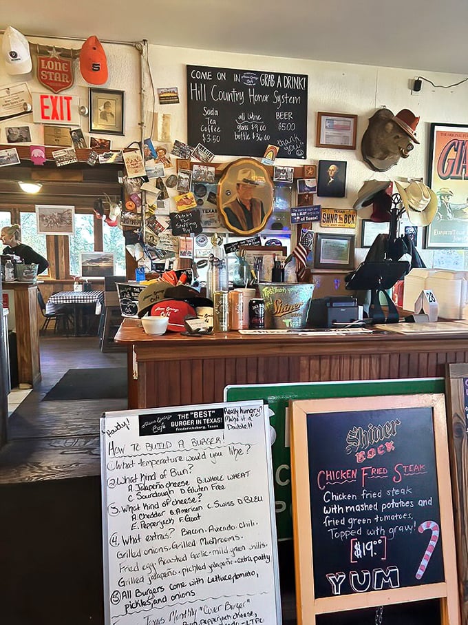 The wall of memorabilia isn't decoration—it's a community scrapbook where every hat, photo and sign tells part of the Hill Country story.
