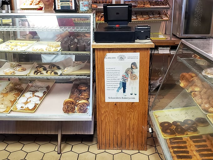 Behind this wooden counter, dreams come true one donut at a time. The hexagon floor tiles have witnessed generations of sugar-fueled happiness.