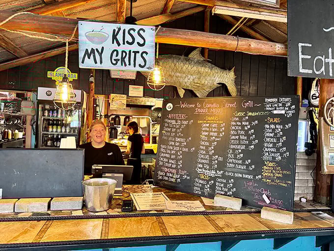 "Kiss My Grits" sign hanging above a smiling face—the universal symbol for "you're about to eat something unforgettably delicious."