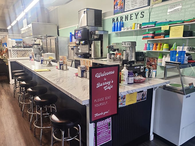The counter where magic happens – stools awaiting your arrival and a "seat yourself" sign that feels like a warm handshake.