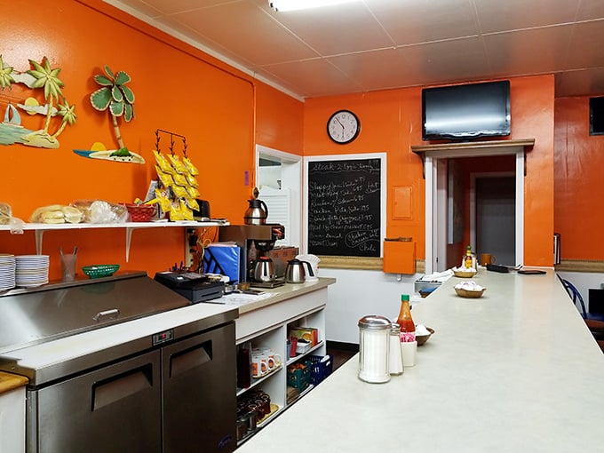 Behind the scenes where breakfast magic happens. Orange walls and a chalkboard menu – the command center of comfort food.