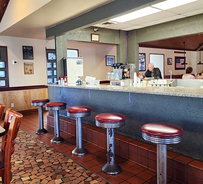 The counter seats—where solo diners become temporary family and waitresses remember your coffee preference after just one visit.