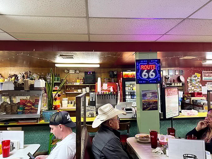 Route 66 memorabilia watches over diners enjoying hearty meals—the perfect pit stop where cowboy hats and baseball caps gather under one roof.