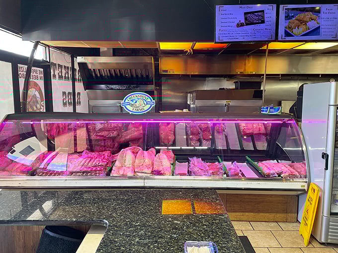The meat case—where barbecue dreams begin and diets go to die. That pink-tinged display light is nature's way of saying "resistance is futile."