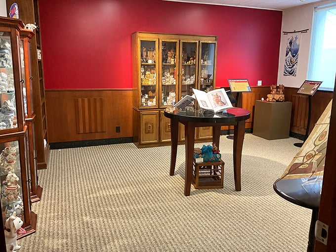 Rich burgundy walls and wooden display cases create a museum atmosphere that's both dignified and accessible – just like cats themselves.