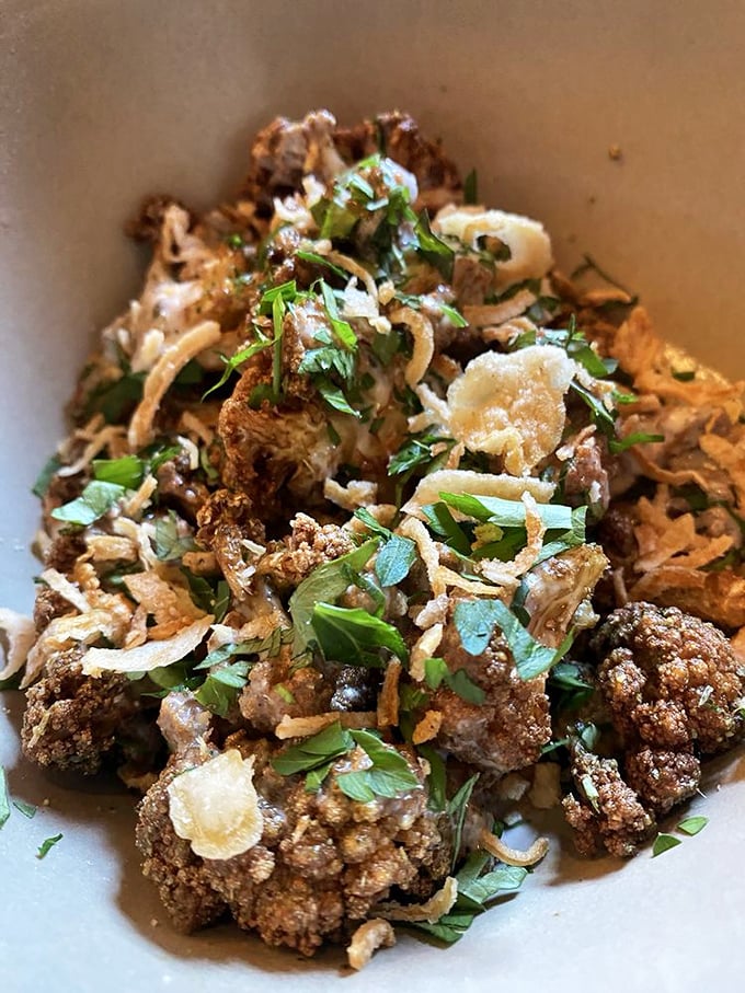 Fried cauliflower elevated to art form – crispy, herbaceous, and making you wonder why you ever boiled vegetables in the first place.