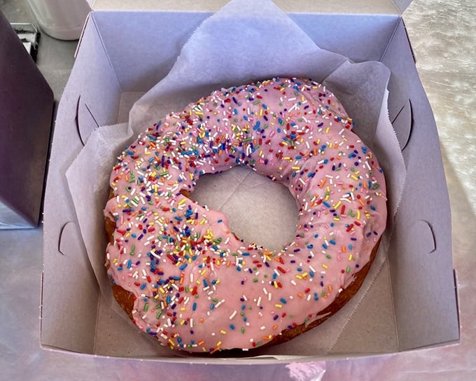 This pink-frosted donut with chocolate drizzle isn't just breakfast—it's a celebration on a paper napkin. Sprinkles optional, joy mandatory.