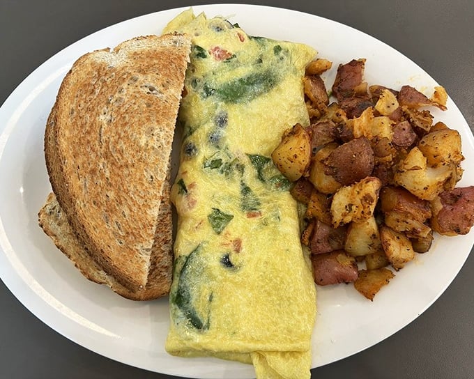This omelet has more green in it than my retirement portfolio, and I'm not mad about it. Paired with those seasoned potatoes, it's health food with a wink.