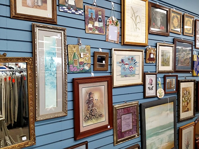 The wall of frames tells a thousand stories, none of them yours yet. That blue backdrop makes each piece pop like an art gallery.