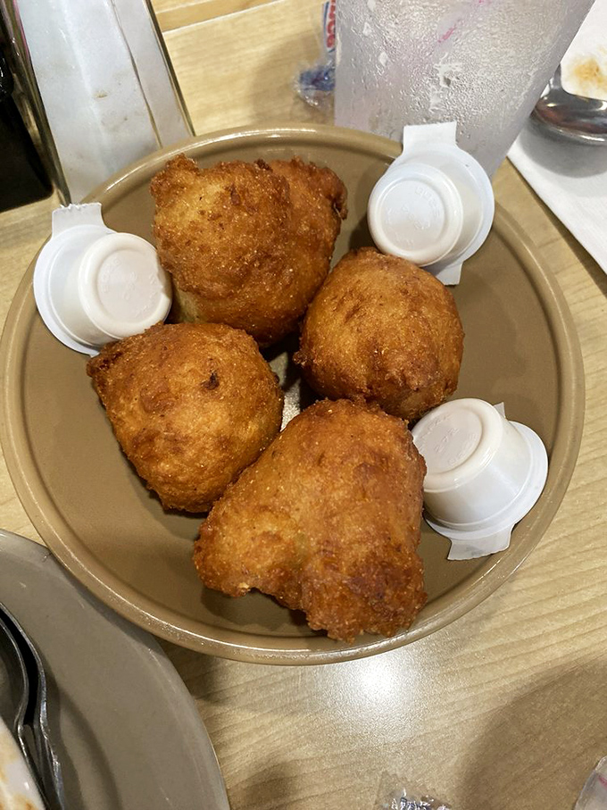 Hushpuppies so perfectly golden they belong in Fort Knox. These crispy cornmeal spheres have silenced hunger pangs for generations.