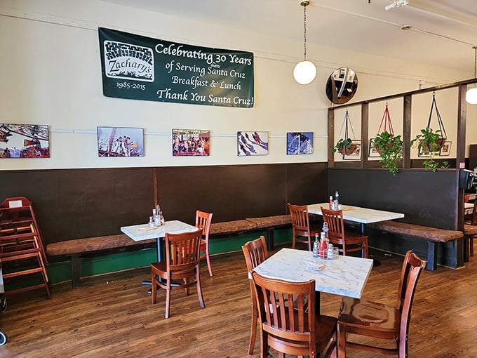Hanging plants and warm wood paneling create dining nooks that feel both private and part of something bigger—like breakfast community theater.