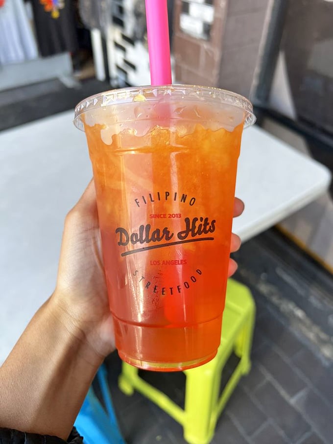This isn't just fruit juice – it's liquid sunshine in a cup, complete with the Dollar Hits logo to remind you where this flavor revelation happened.
