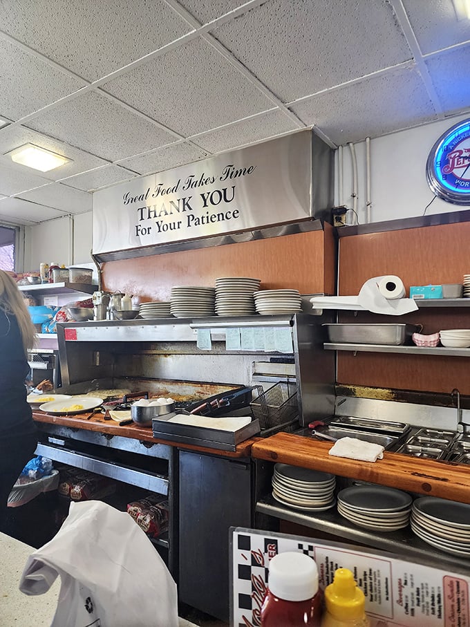 "Great Food Takes Time"—the banner speaks truth while the kitchen ballet unfolds beneath it, a choreography of spatulas and short-order mastery.