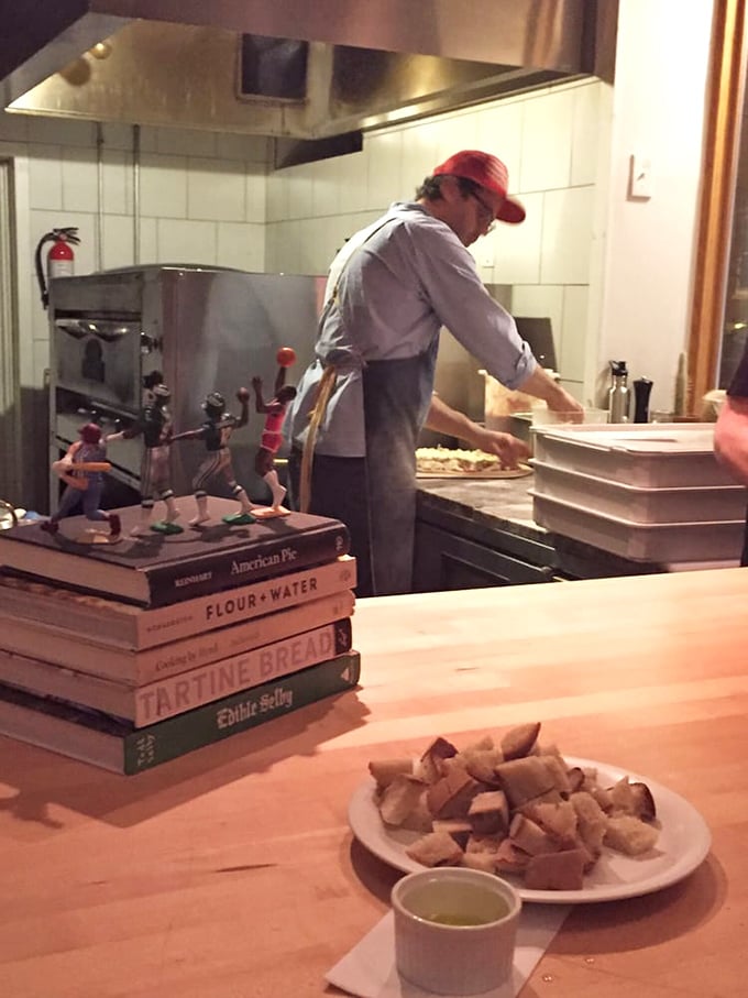 Where the magic happens—cookbooks stacked like sacred texts beside the tools of the trade. Serious craft at work.