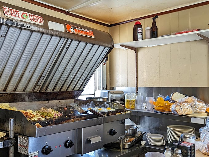 The well-seasoned flat-top grill—where breakfast magic happens and decades of flavor have seasoned every square inch.