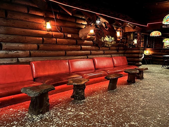 The waiting area's red leather bench – where anticipation builds and the aroma of grilled meat makes those minutes feel like delicious torture.