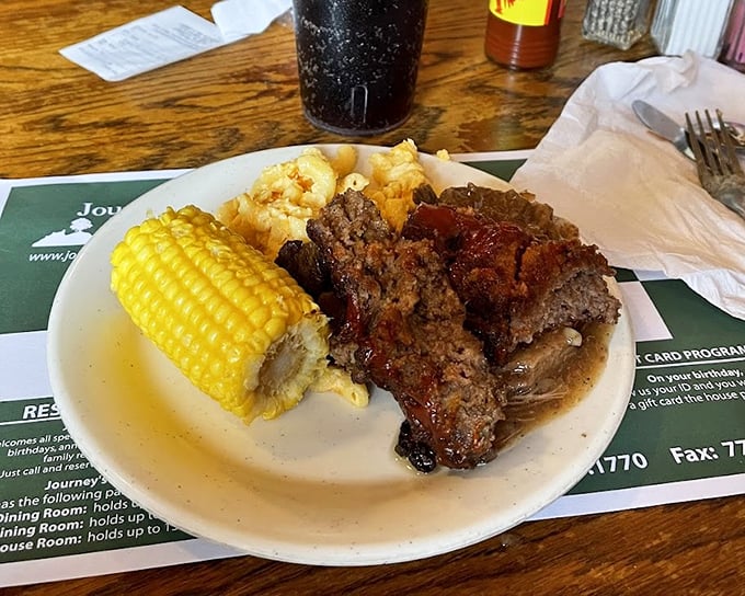 Homestyle meatloaf with a glistening tomato glaze alongside buttery corn on the cob—comfort food that speaks directly to your childhood memories.