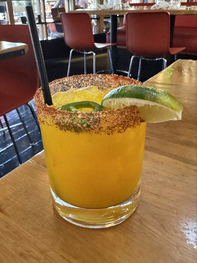 This sunshine-colored cocktail with its spiced rim and lime garnish offers a California twist on classic cocktail traditions—refreshing and camera-ready.