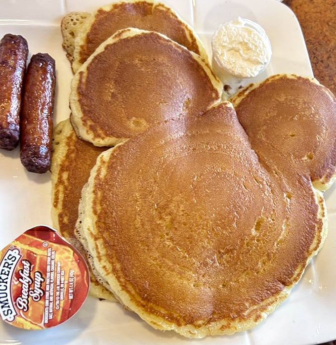 Mickey would approve of these golden pancakes served alongside sausage links—childhood nostalgia on a plate that brings smiles to diners of all ages.