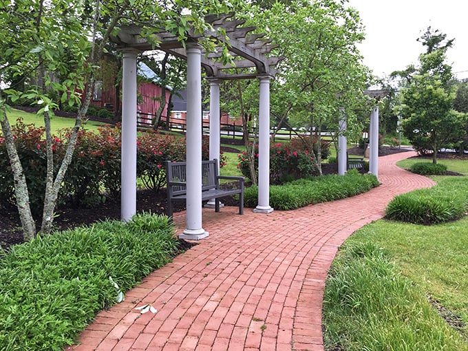 This pergola-lined brick pathway invites contemplative strolls through Mill Park's manicured gardens—nature's version of a stress-relief prescription.