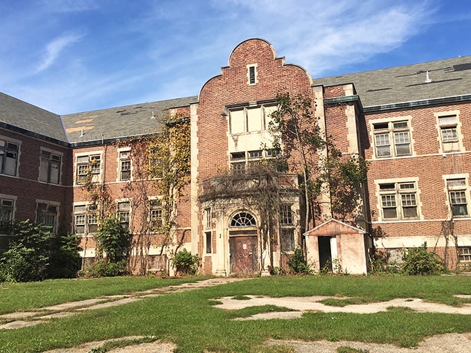 Ivy climbs the façade like nature's own memorial, softening the hard edges of a building designed for institutional efficiency.