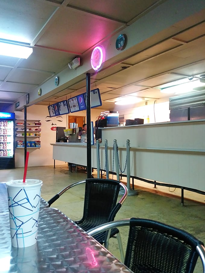 The concession area awaits with its familiar glow, where movie break conversations flow as freely as the fountain drinks.