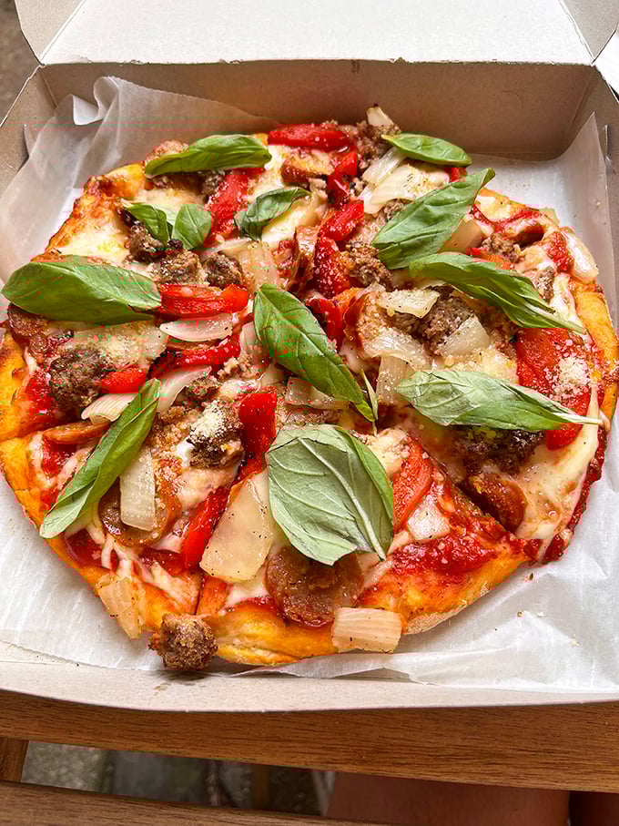 Fresh basil leaves dancing atop a meat lover's dream—proof that vegetables and carnivorous delights can coexist beautifully.