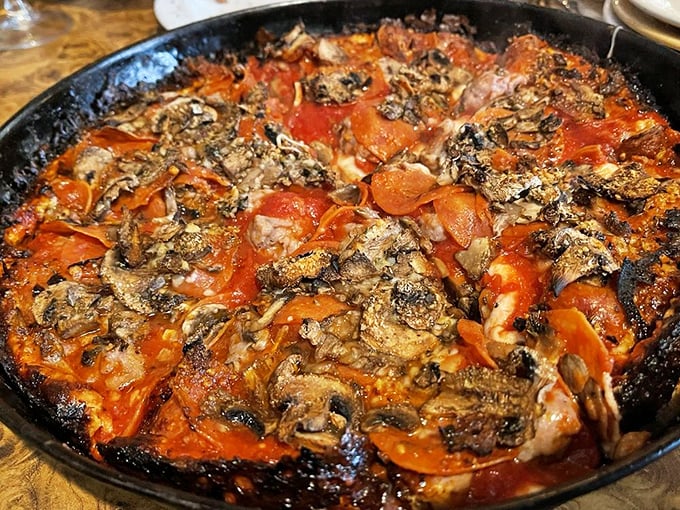 The holy trinity of pizza toppings—sausage, pepperoni, and mushrooms—having a flavor party in a perfectly seasoned cast iron pan.