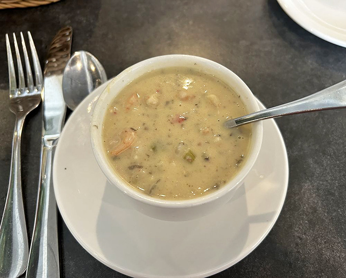 The seafood bisque whispers tales of the nearby lake, creamy enough to make you consider drinking it straight from the bowl.