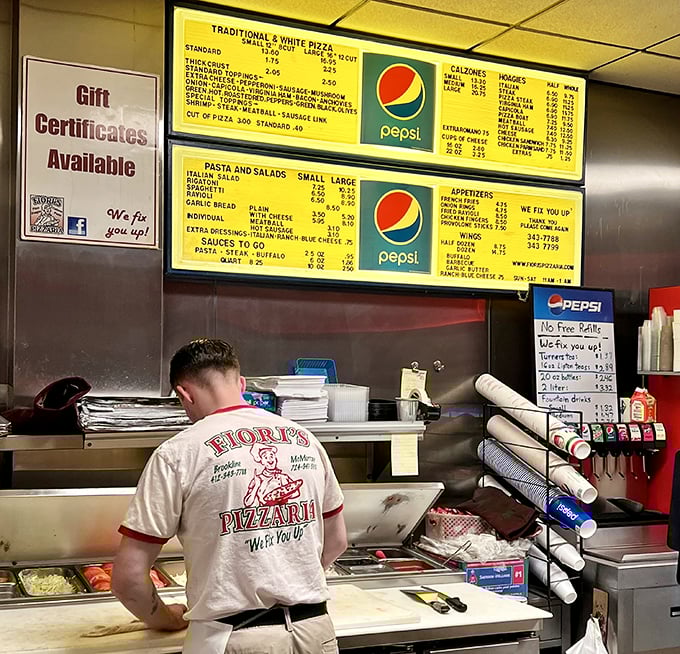 The back of a Fiori's shirt says it all—"We Fix You Up"—as staff prepare the day's therapy sessions one pizza at a time.