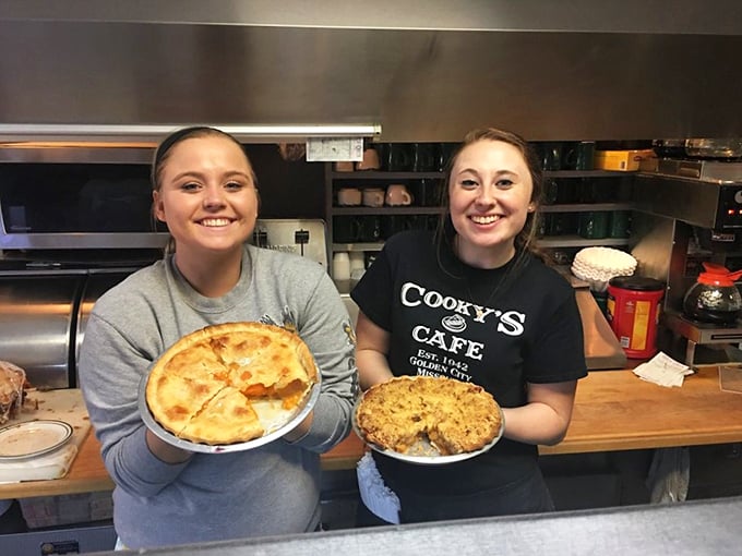 The staff proudly displaying their handiwork—homemade pies that aren't just desserts but edible ambassadors of Golden City's hospitable spirit.
