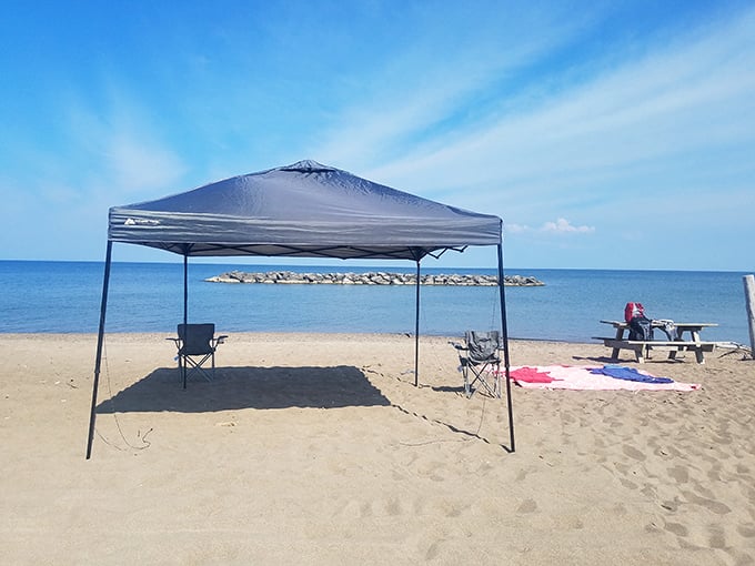 Beach day headquarters established with military precision—this canopy setup claims territory while providing shade that SPF 100 can't match.