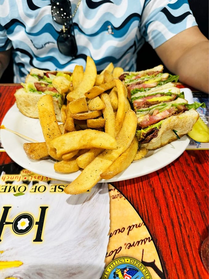 Turkey clubhouse sandwich towering with pride, accompanied by golden fries that know their supporting role perfectly well.