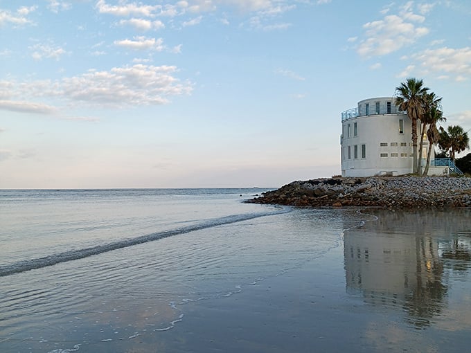 The iconic "Wedding Cake House" reflects in tidal waters like a dream. Part fortress, part fantasy – it's the kind of home that makes you wonder about its stories.