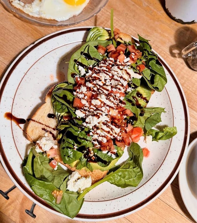 This isn't just avocado toast—it's California's edible business card, dressed up with fresh greens, tomatoes, and a balsamic drizzle.