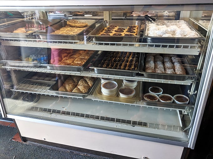 The pastry case stands as a monument to sweet temptation – each tray promising the perfect ending to your Greek feast.